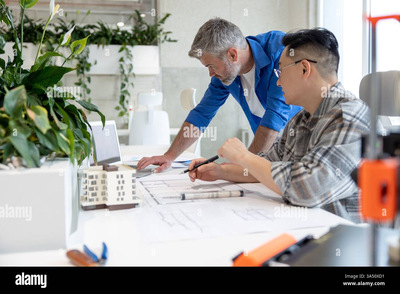 Experimental engineers men working with 3D printer and blueprint for designing mechanical parts ...