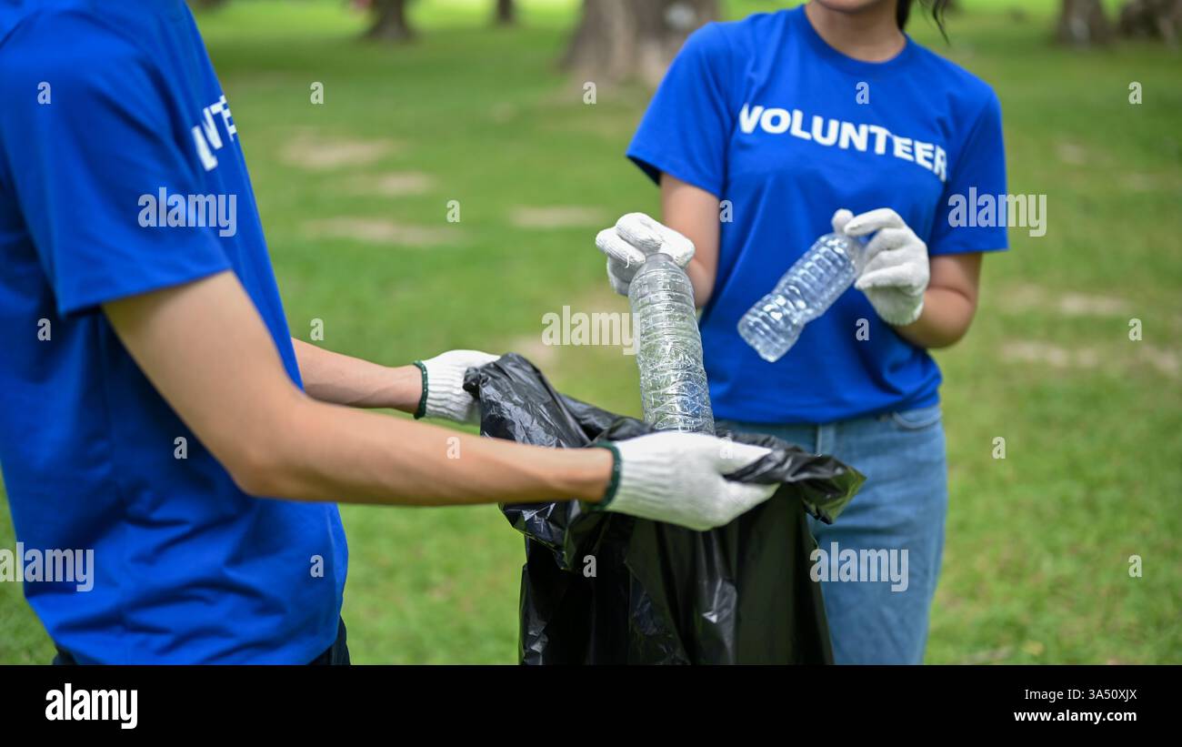 Cropped image of a group of volunteers collecting trash and helping ...