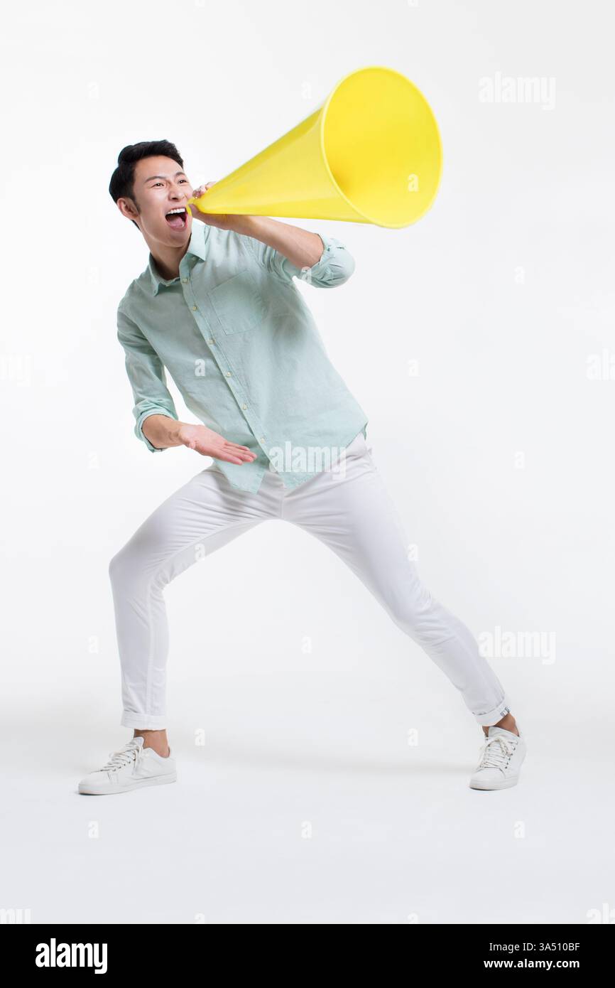 Chinese man shouting on megaphone looking away while standing against ...