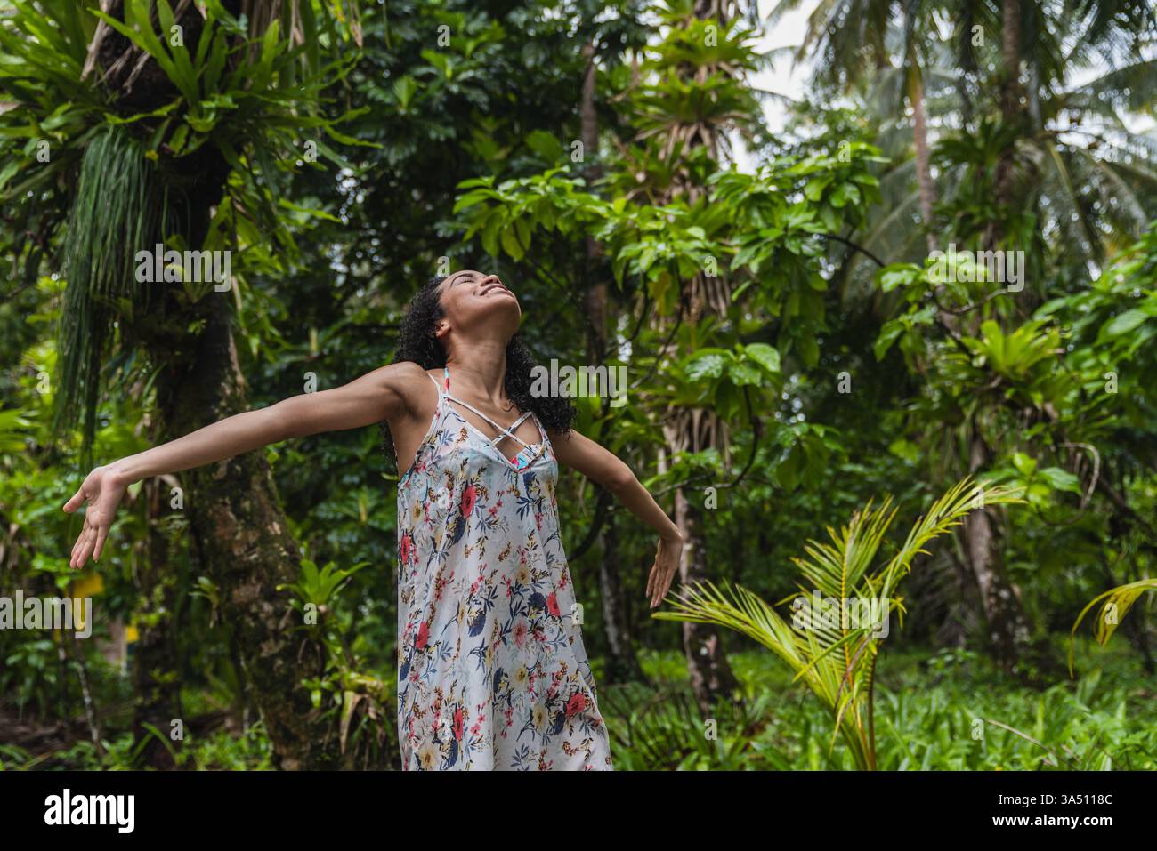 Hispanic woman with head tilted backwards spreading arms standing in ...