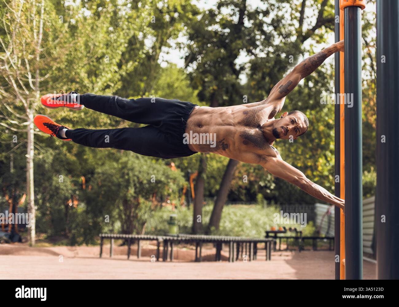 Fit man doing push ups on parallel bar training triceps and biceps ...