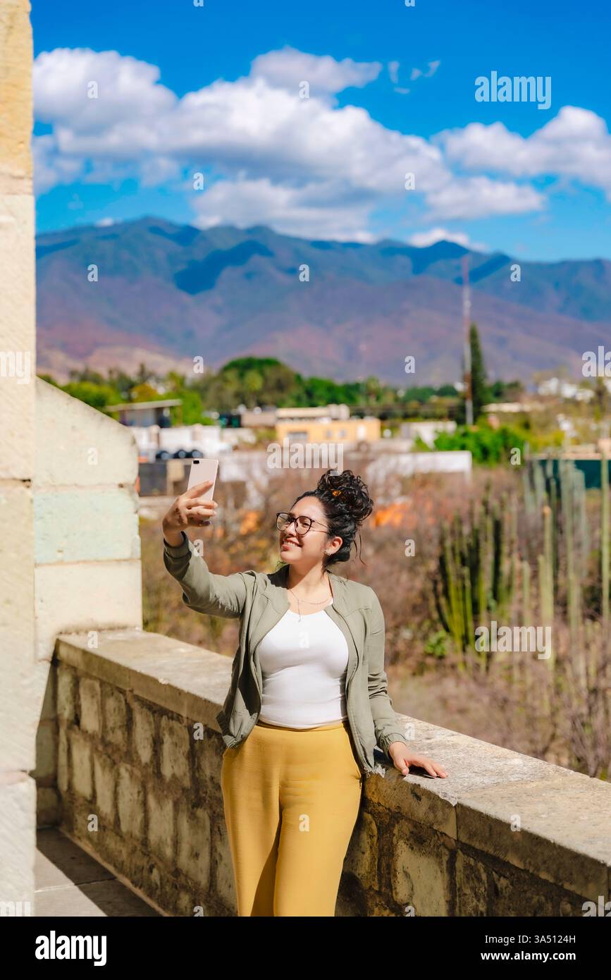 Hispanic woman takes a selfie at a historic building balcony with a ...