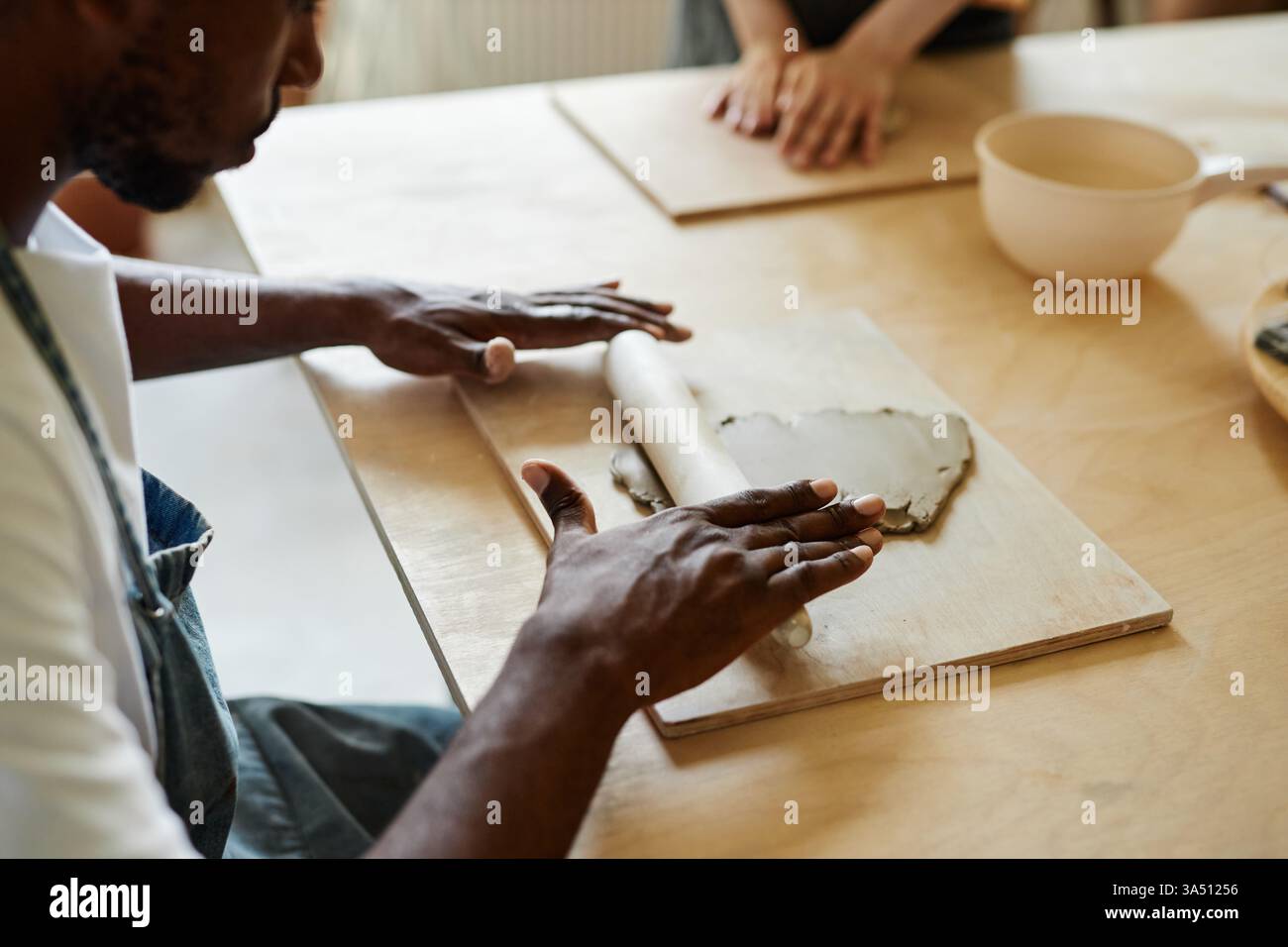 Close-up of male hands shaping clay in a pottery studio during an art ...