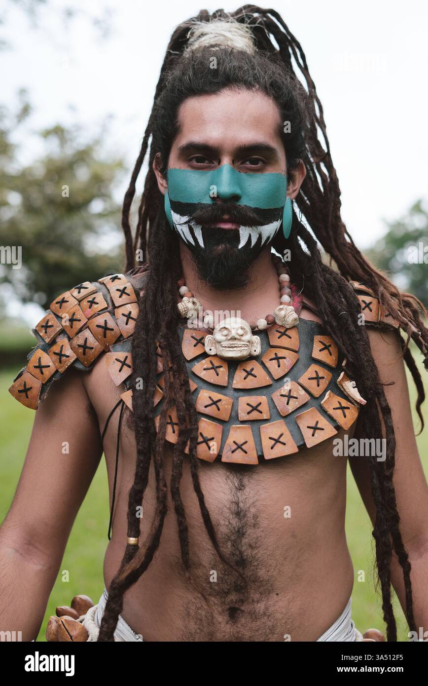 Dreadlocked Mayan warrior in traditional costume with face paint stands ...