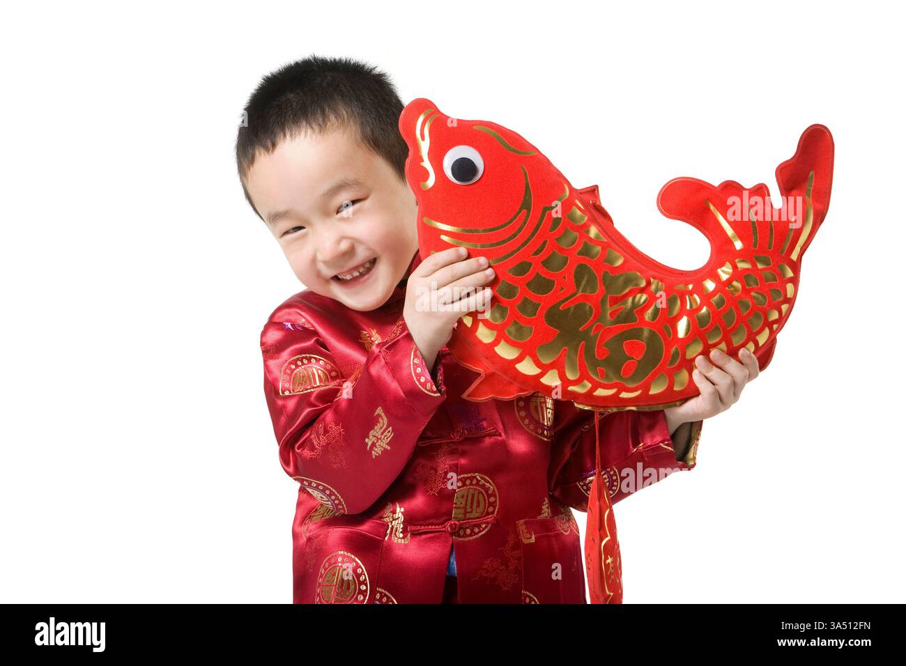 Boy in Chinese traditional clothes holding fish decoration Stock Photo ...