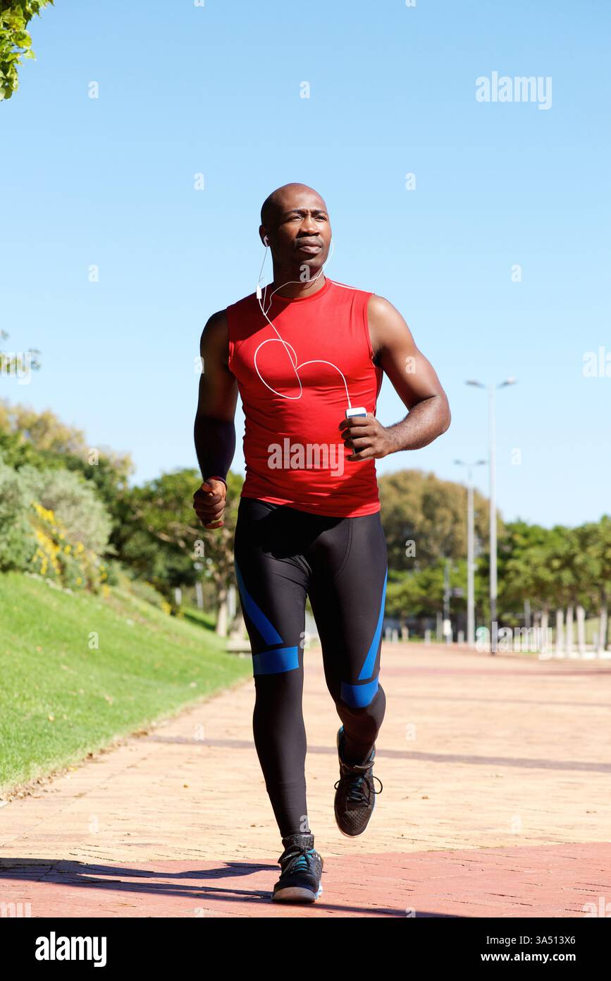 Full body portrait of fit young african man running outdoors at the ...
