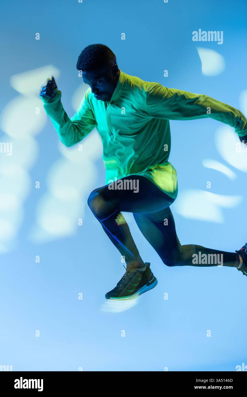 Young Black male in track suit in running stance Stock Photo - Alamy