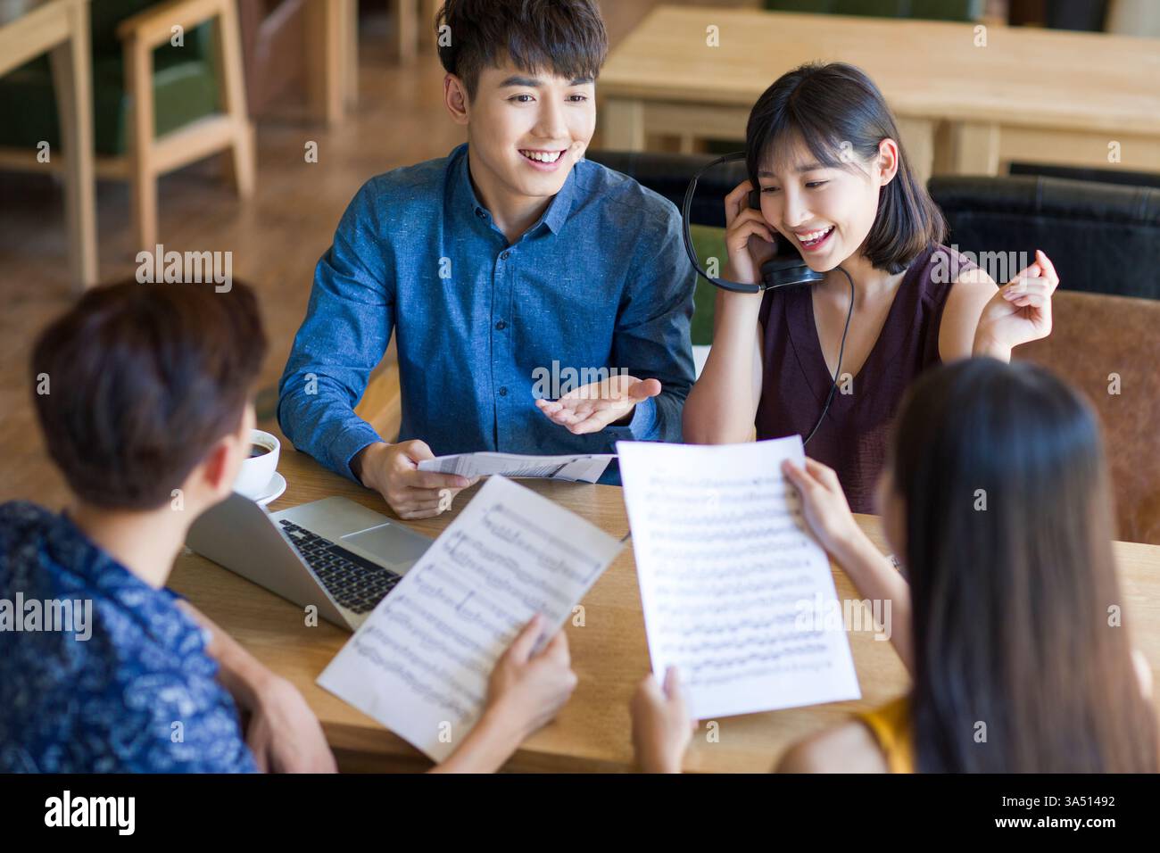 Young Chinese friends talking about music in cafe Stock Photo - Alamy