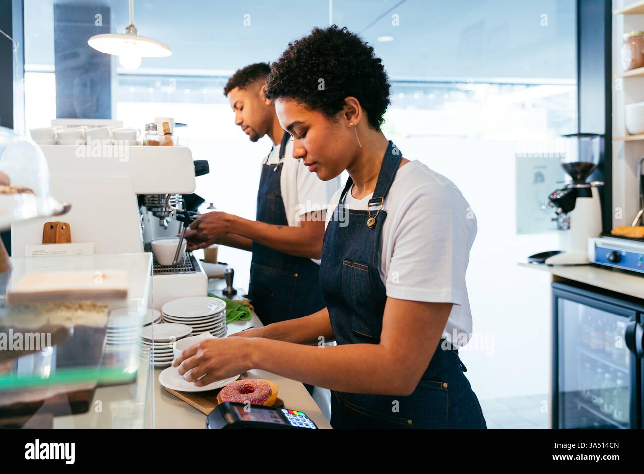 Diverse group of baristas wearing apron working together at kitchen in ...