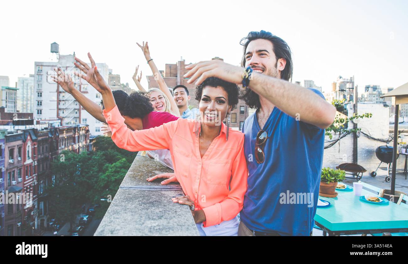 Cheerful Black woman with afro raising arm leaning on edge with male ...