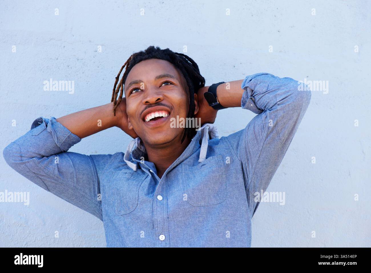 Close up portrait of cheerful african man laughing with hands behind ...