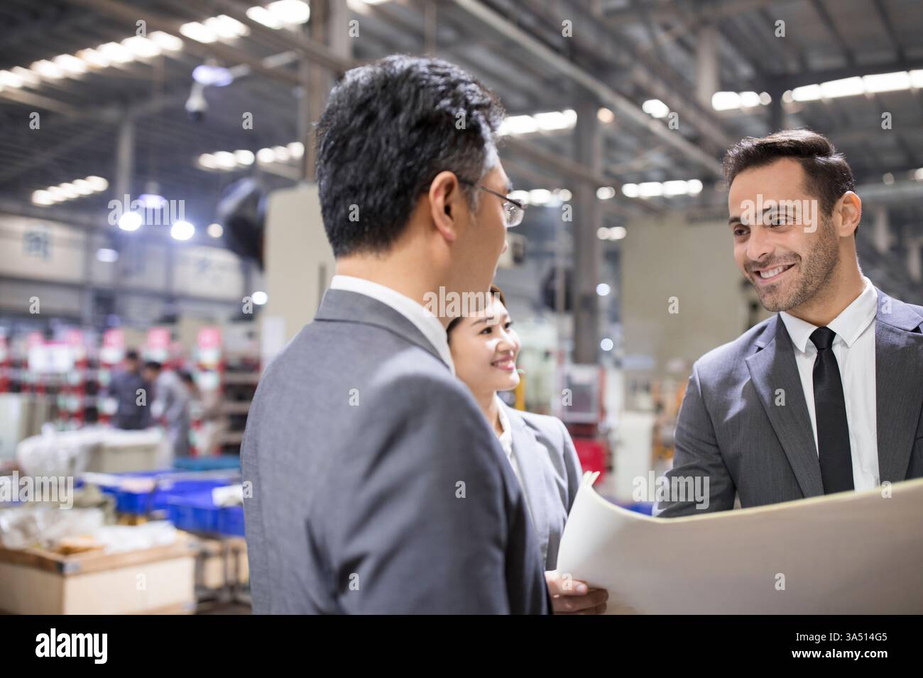 Chinese businessman and woman talking to Hispanic male business partner ...