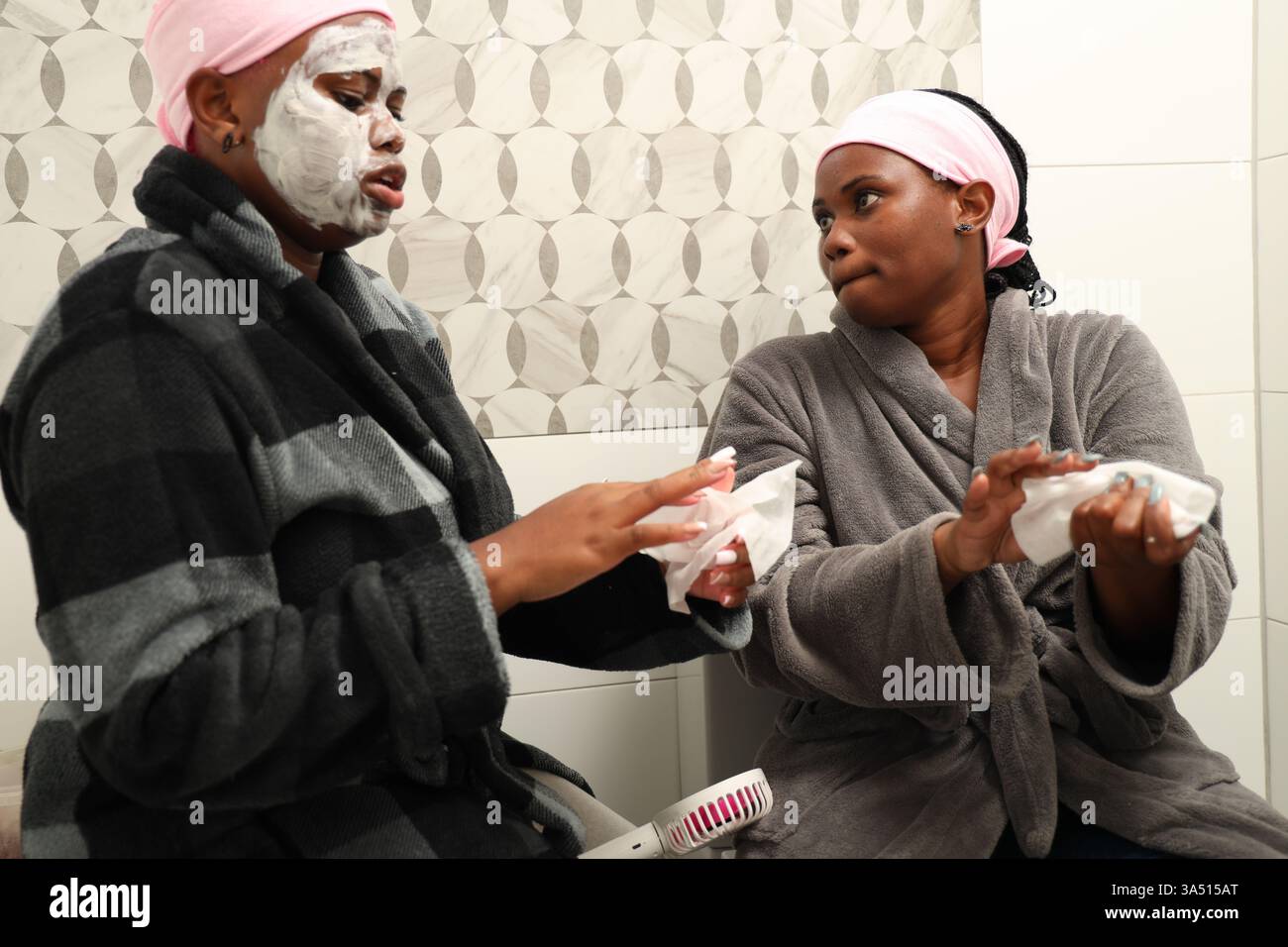 Black teen female and woman talking to each other wiping both hands ...