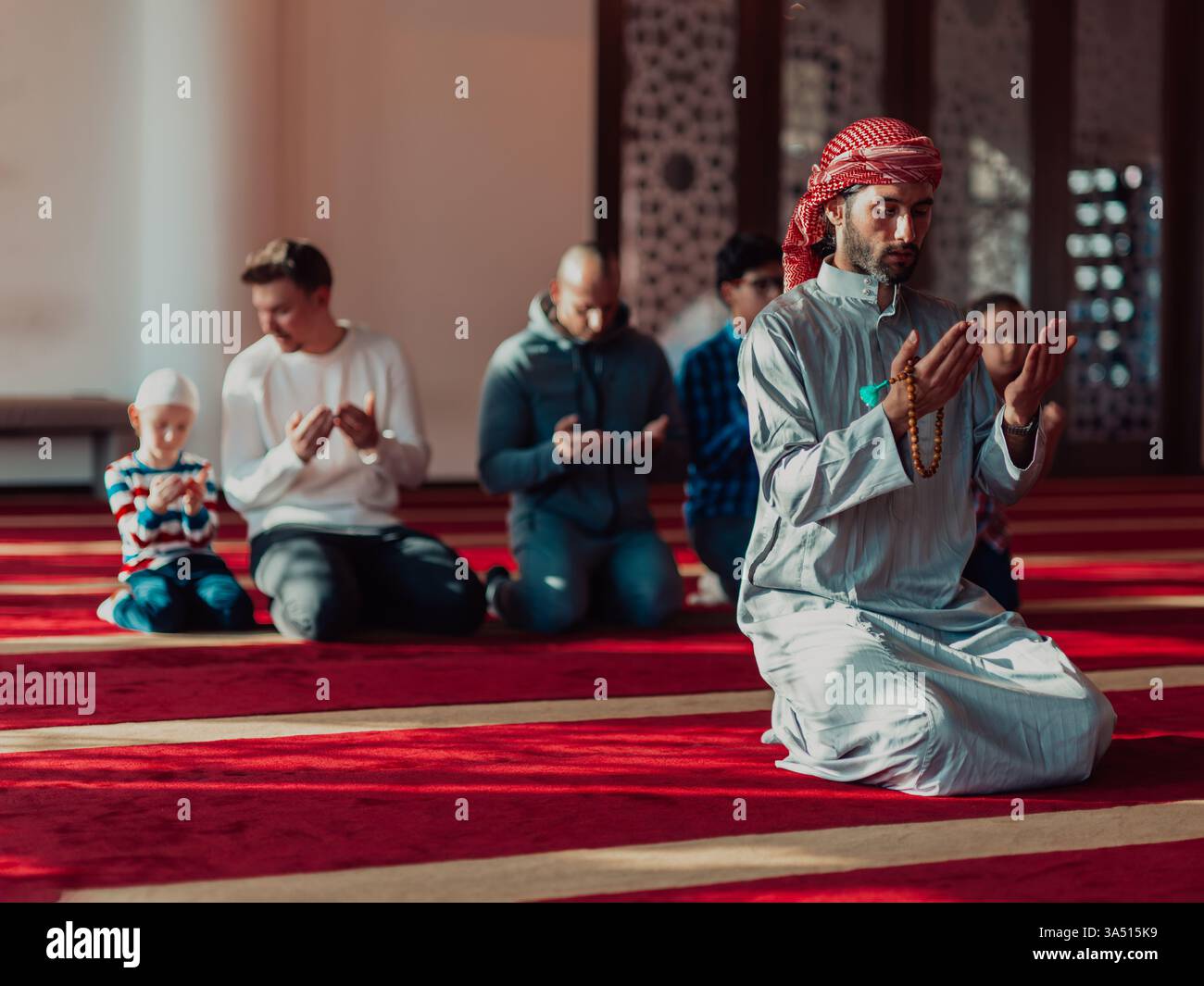A group of Muslims in a modern mosque praying the Muslim prayer namaz ...