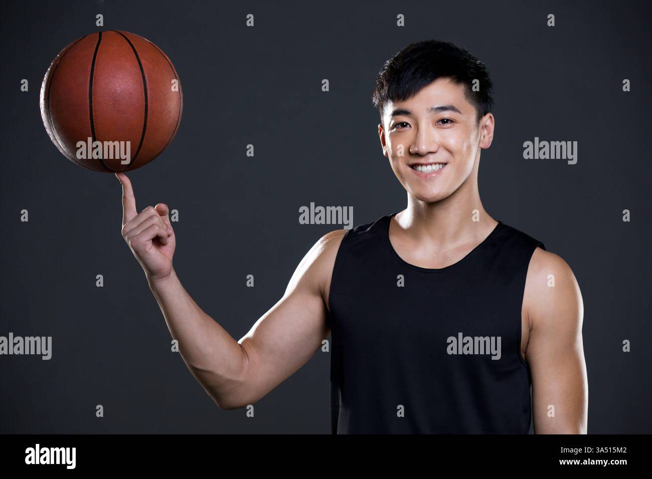 Young Chinese man spinning basketball on finger Stock Photo - Alamy