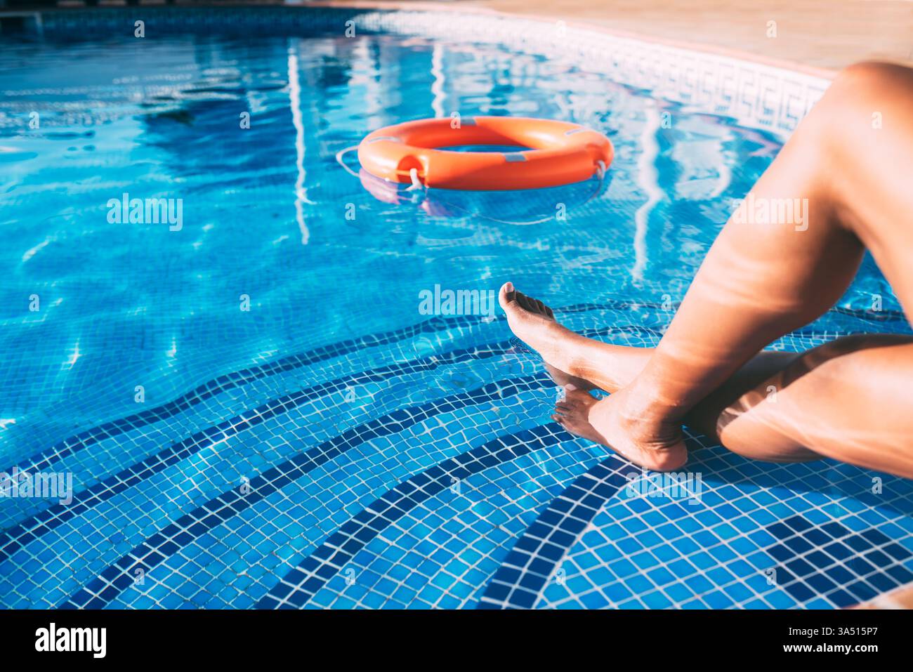 Relaxed poolside scene featuring a Black woman with legs in a swimming ...