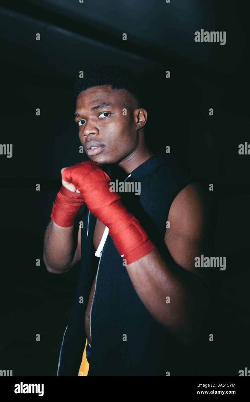 African American boxer with hand wraps stands ready in a training ...