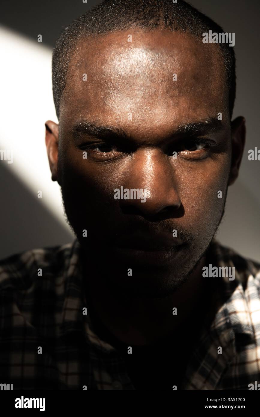 Close up portrait african american man staring with light across face ...