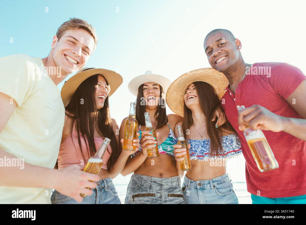 Group of friends spending time on the beach together celebrating ...