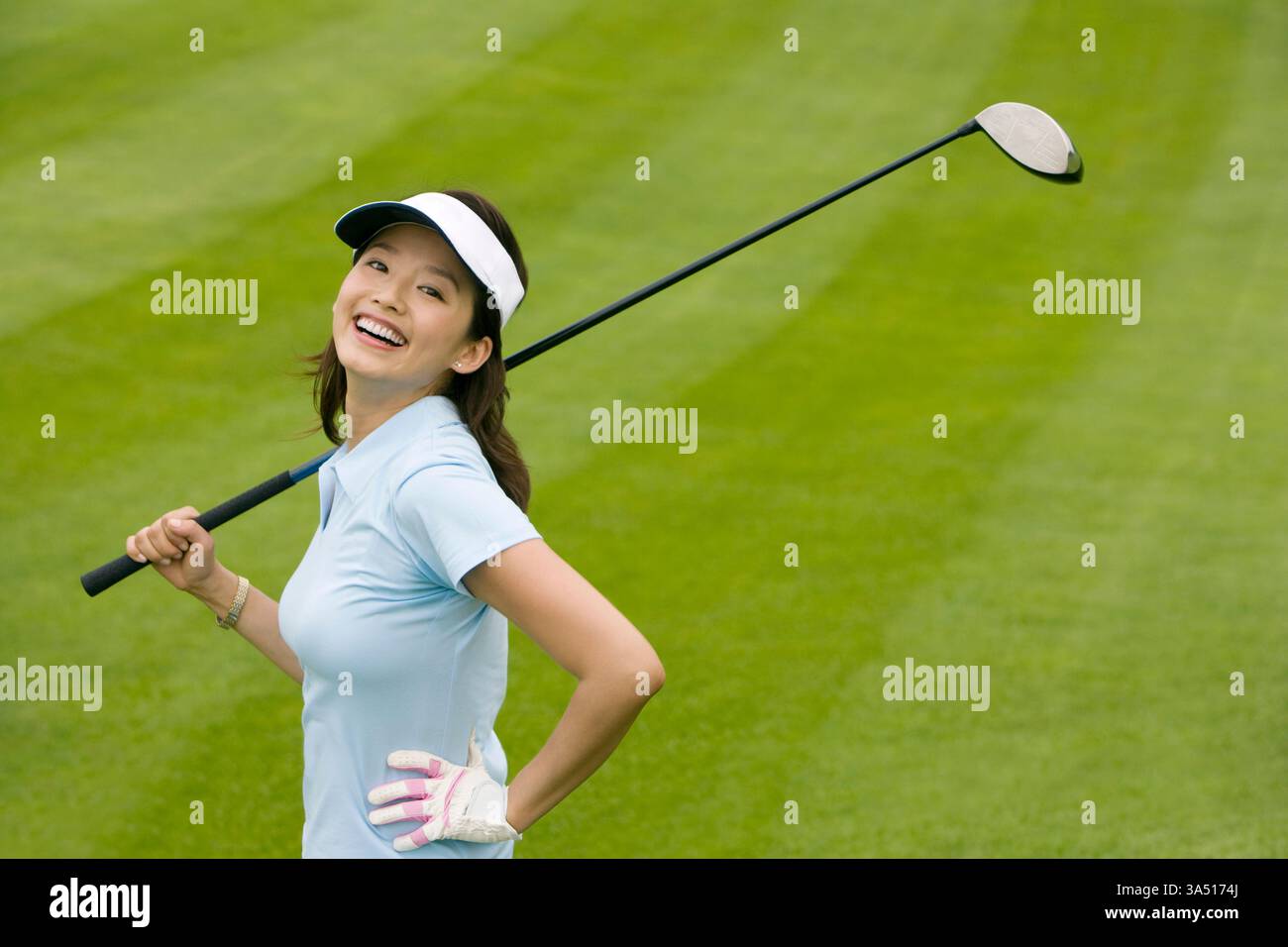 Portrait of a smiling female Chinese golfer, club in hand Stock Photo ...