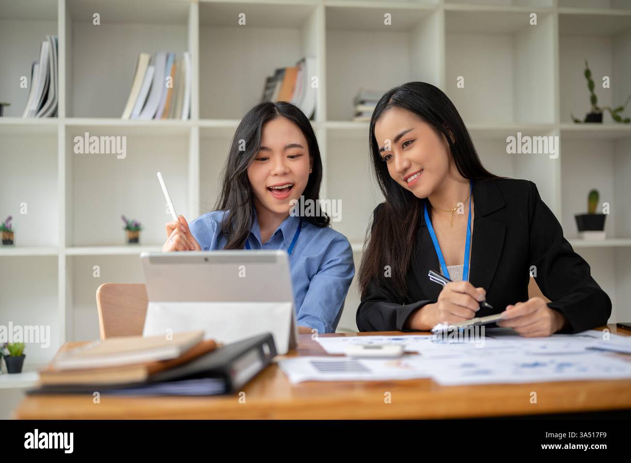 Two attractive Asian female accountants are working on financial ...