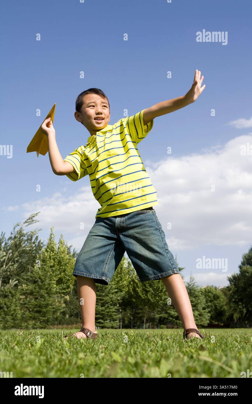Chinese boy playing with a paper airplane Stock Photo - Alamy