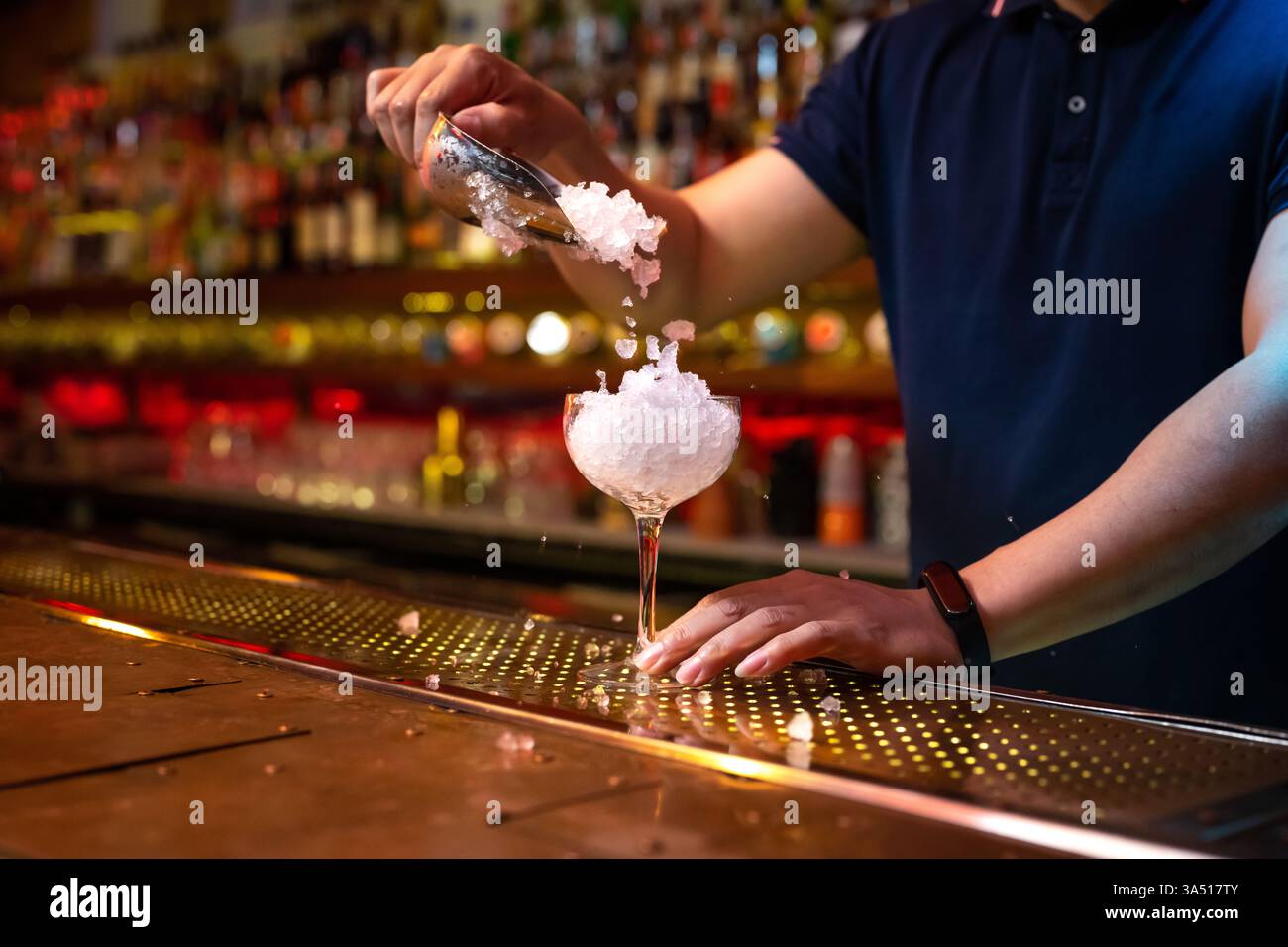Asian male bartender putting crushed ice into glass while preparing cocktail Stock Photo - Alamy