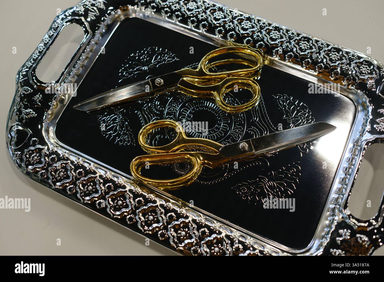 Brightly lit area features detailed silver tray showcasing golden ...