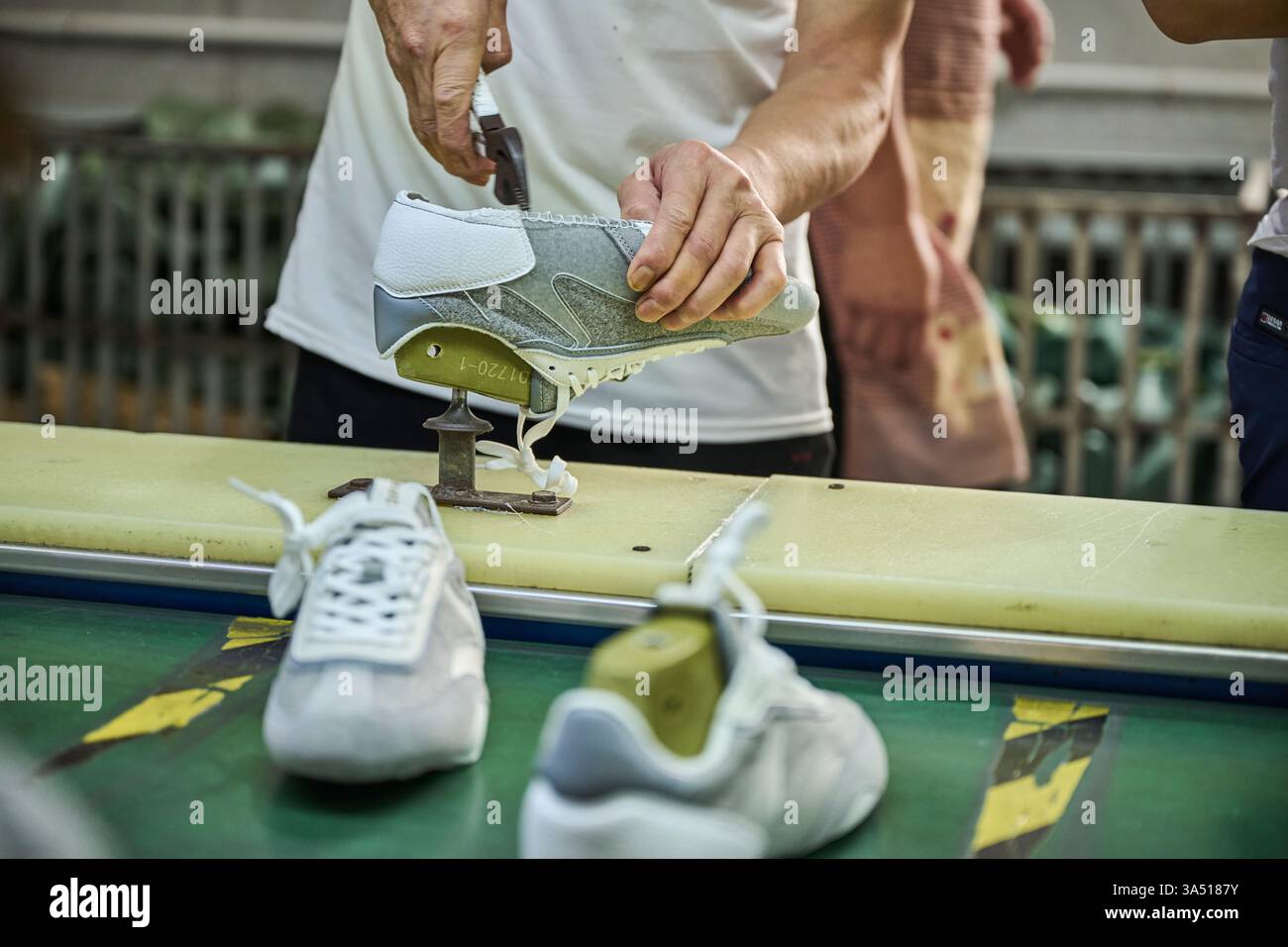 Asian worker doing task in production line at shoes factory Stock Photo ...