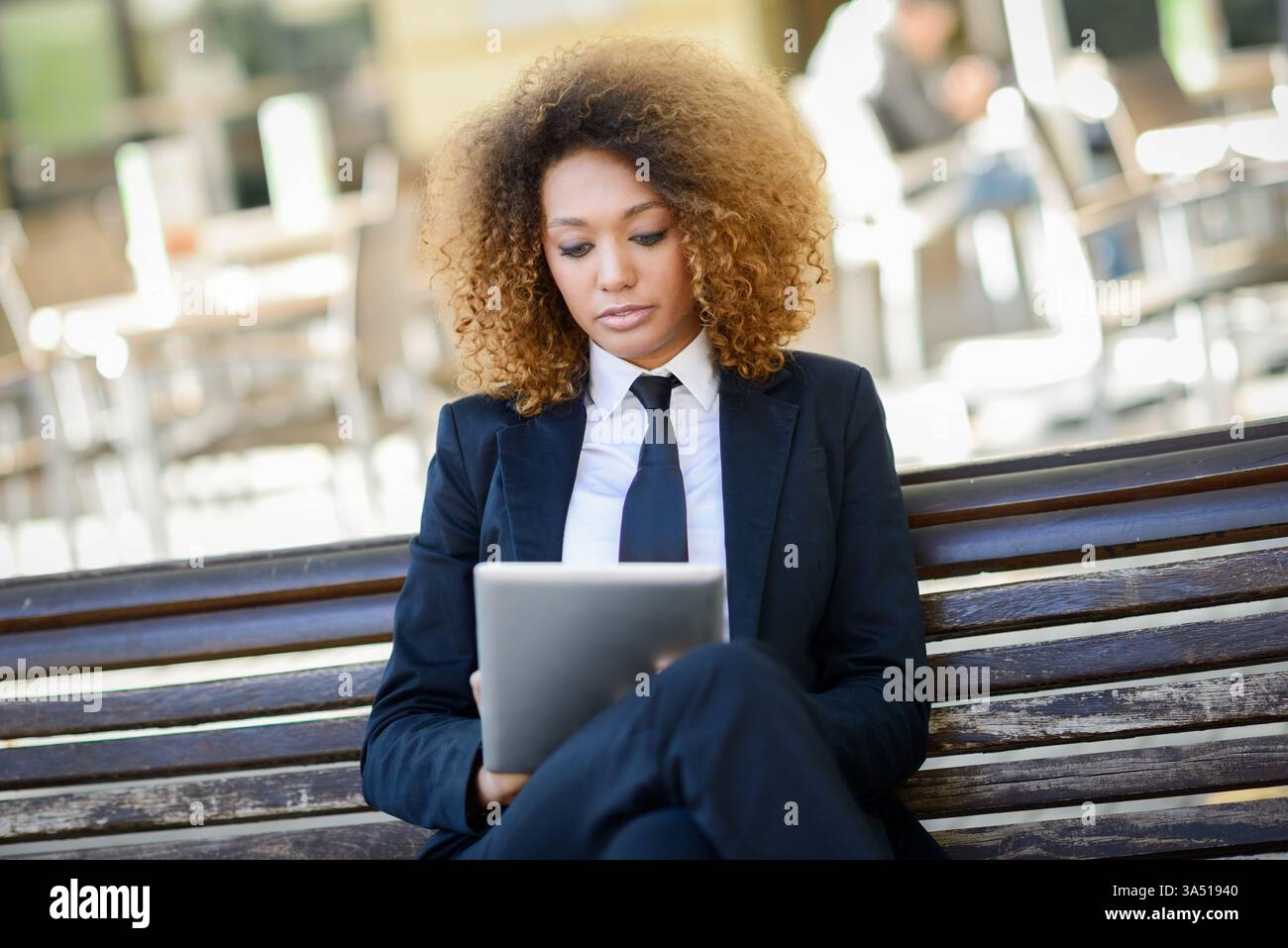 Beautiful black curly hair african woman using tablet computer on an ...