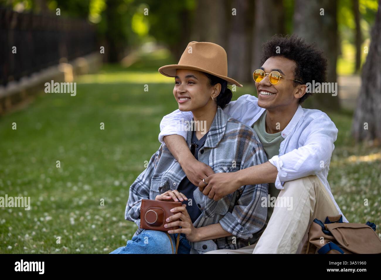 Romantic. Young cute couple sitting on the grass and looking romantic ...