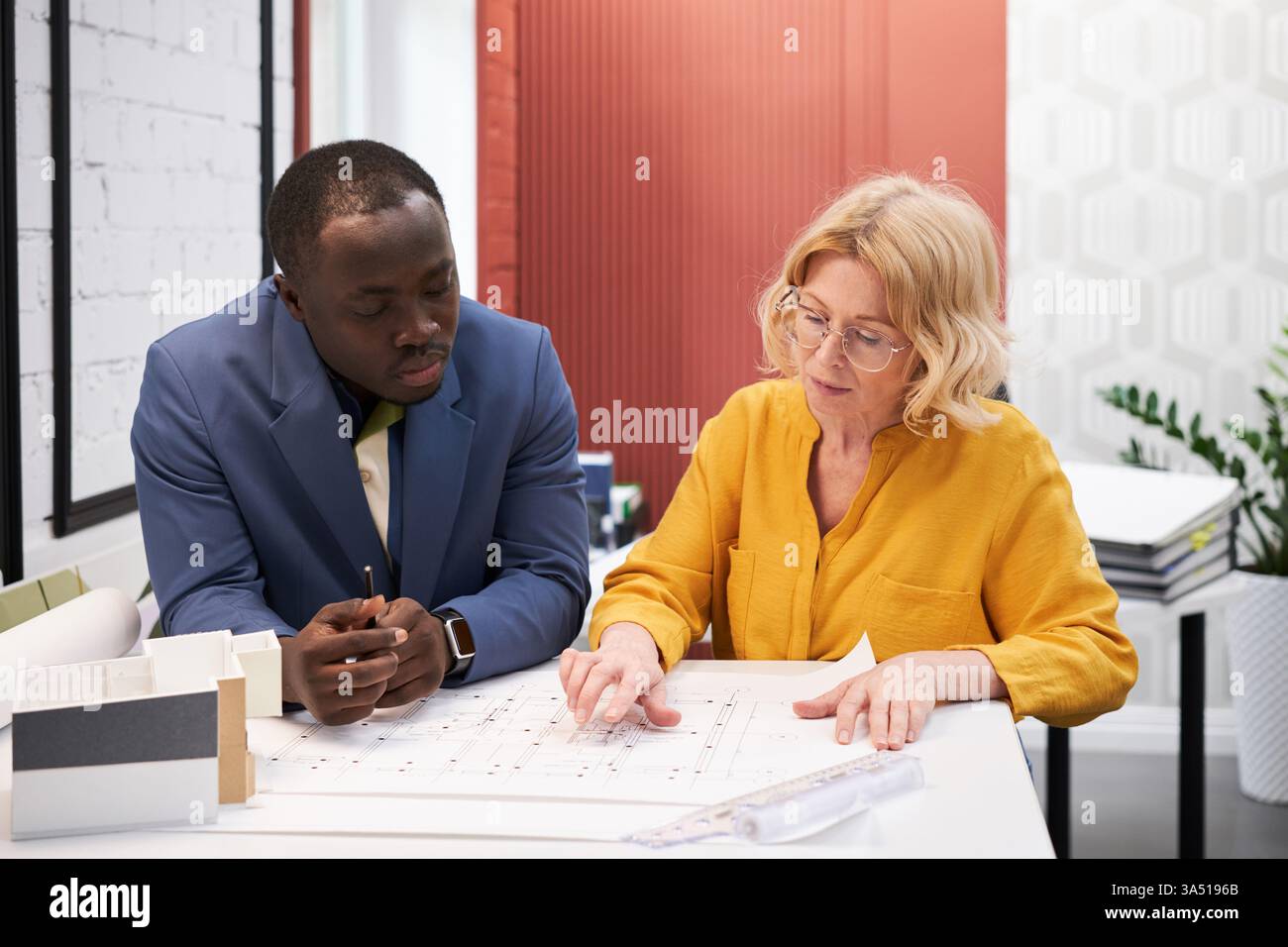 Focused Black businessman sitting together with caucasian female ...