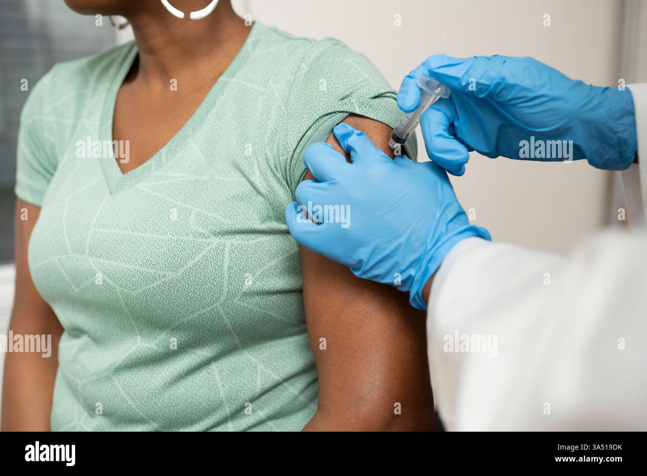 Female patient receiving vaccine into arm Stock Photo - Alamy