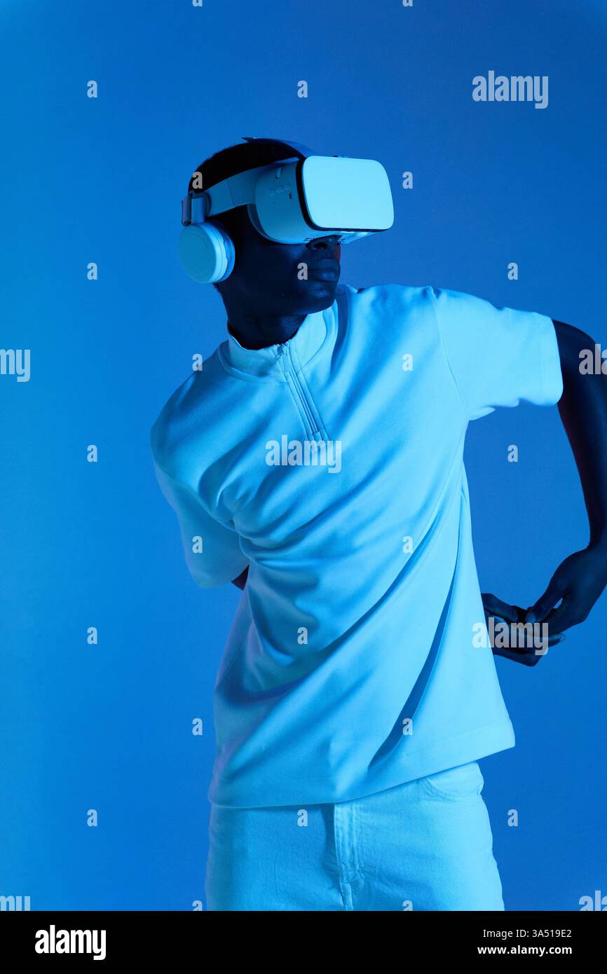 Cool young African American male in white outfit and futuristic VR ...