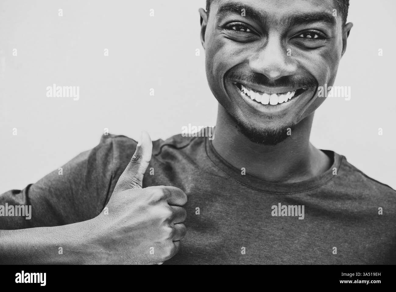 Close up black and white portrait smiling young black man with thumbs ...