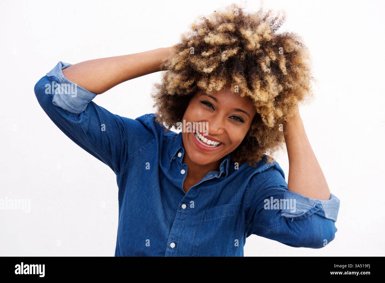Cheerful Black woman with blonde afro hairstyle standing with hands on ...