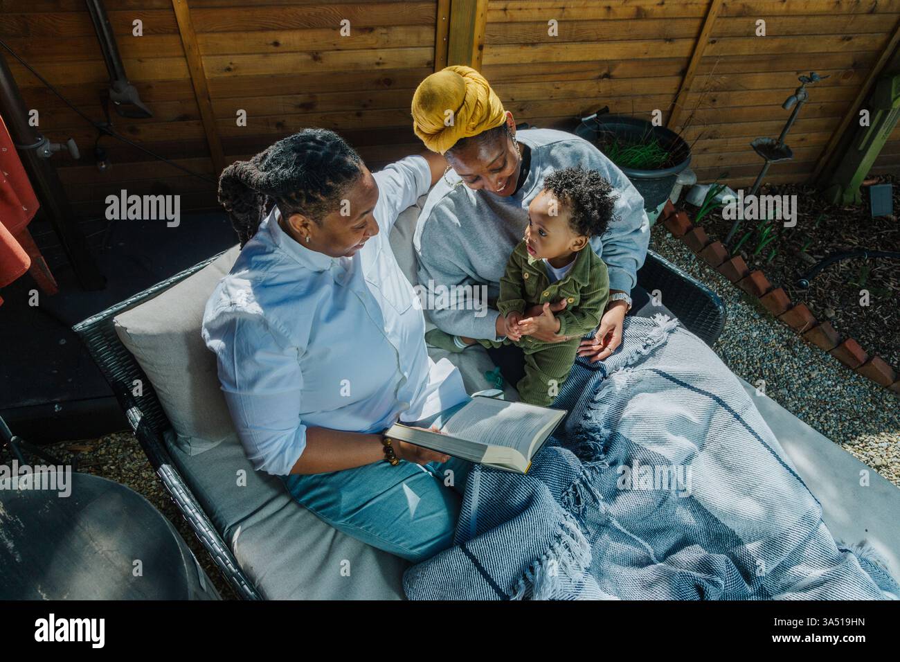 High-angle scene of a Black non-binary person reading a book with their ...