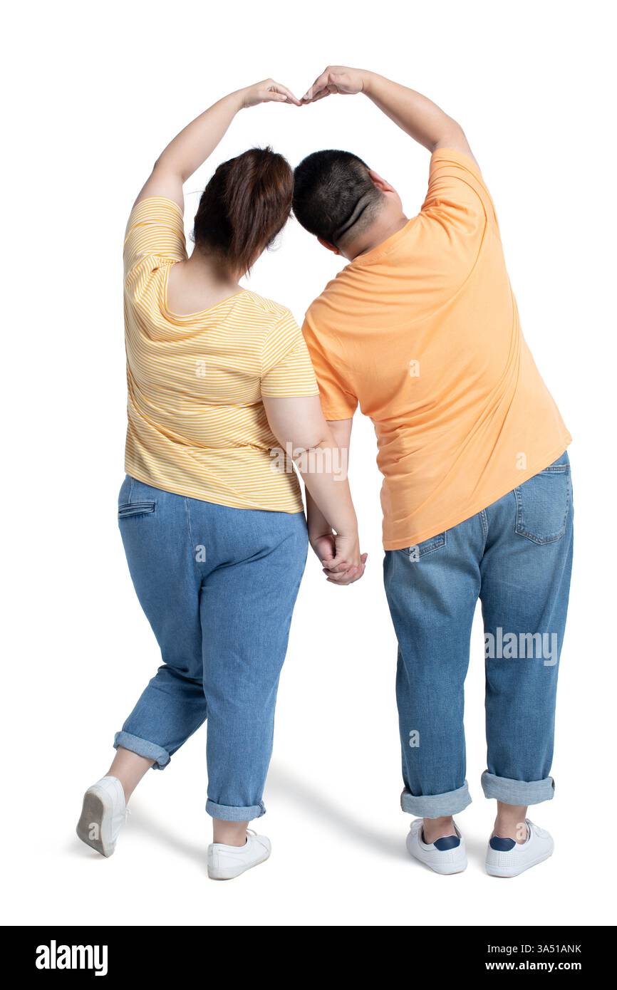 Plus size Chinese couple holding hands and making heart hand gesture ...