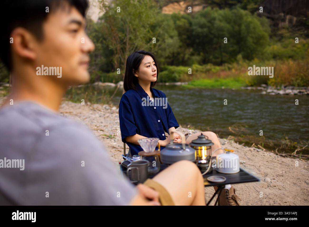 Happy young Chinese couple camping outdoors Stock Photo - Alamy