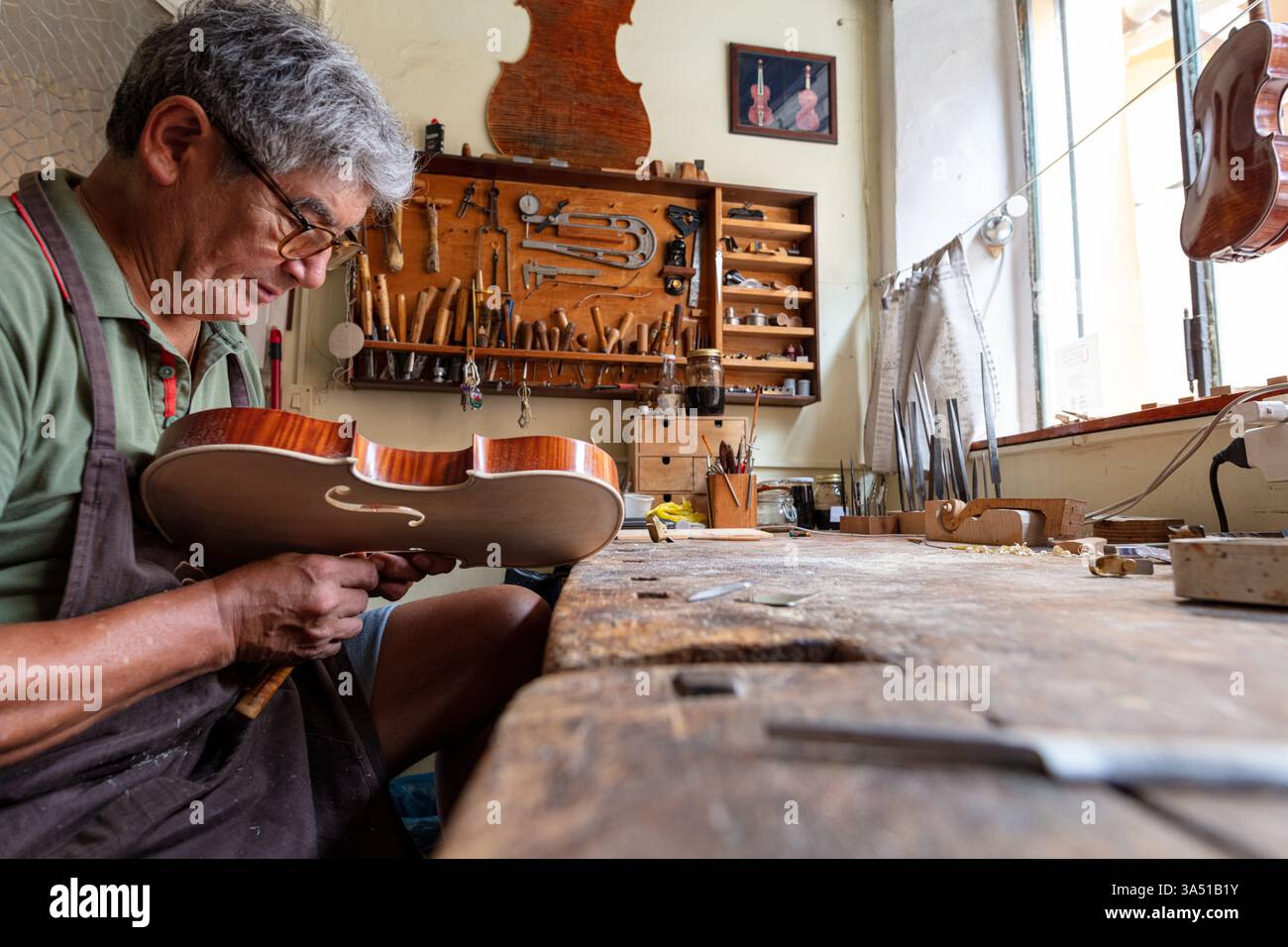 Violin maker at work in a traditional Italian workshop. Perfect for ...