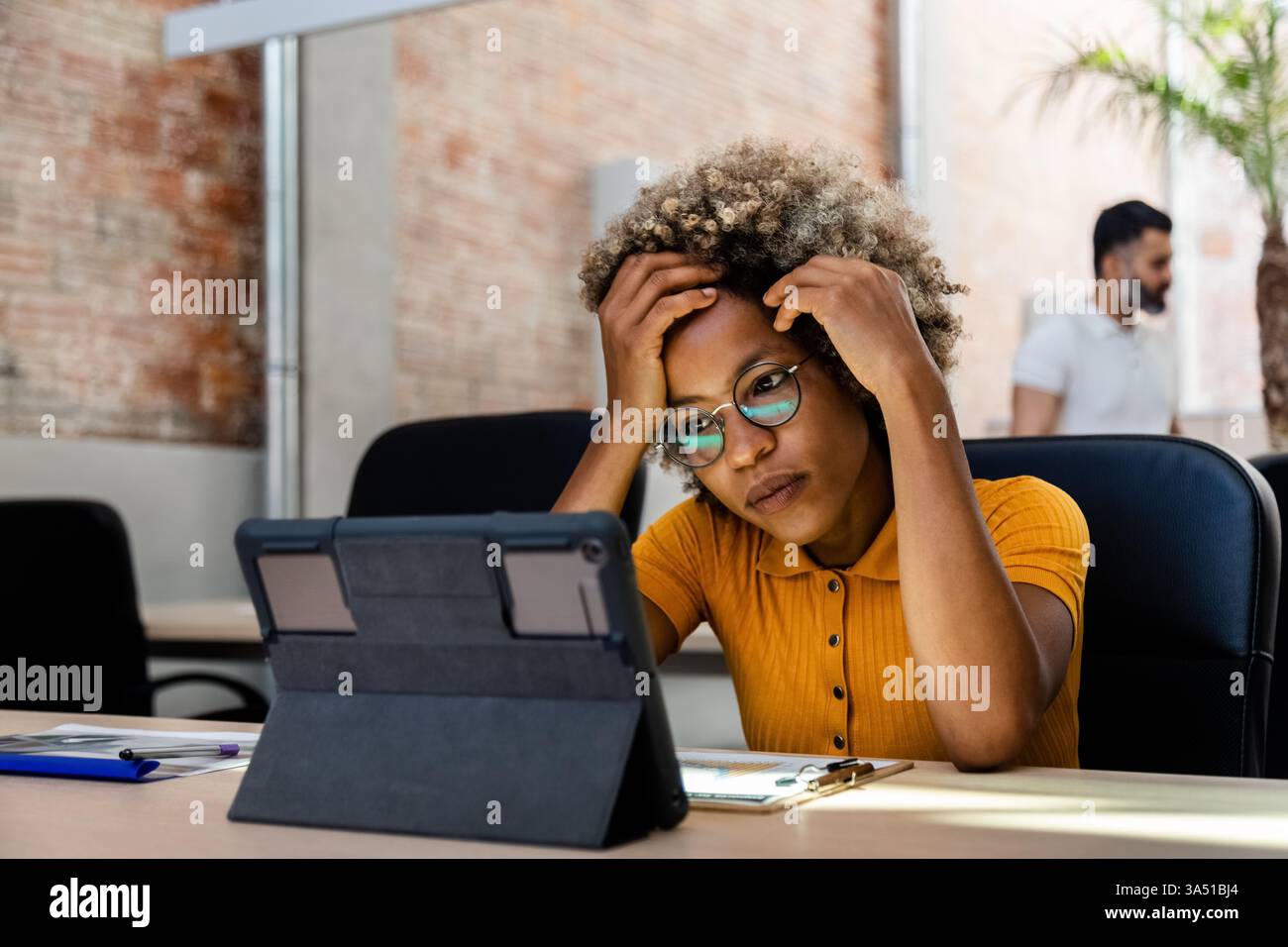 Tired African American young woman working in the office. Forehead rest ...