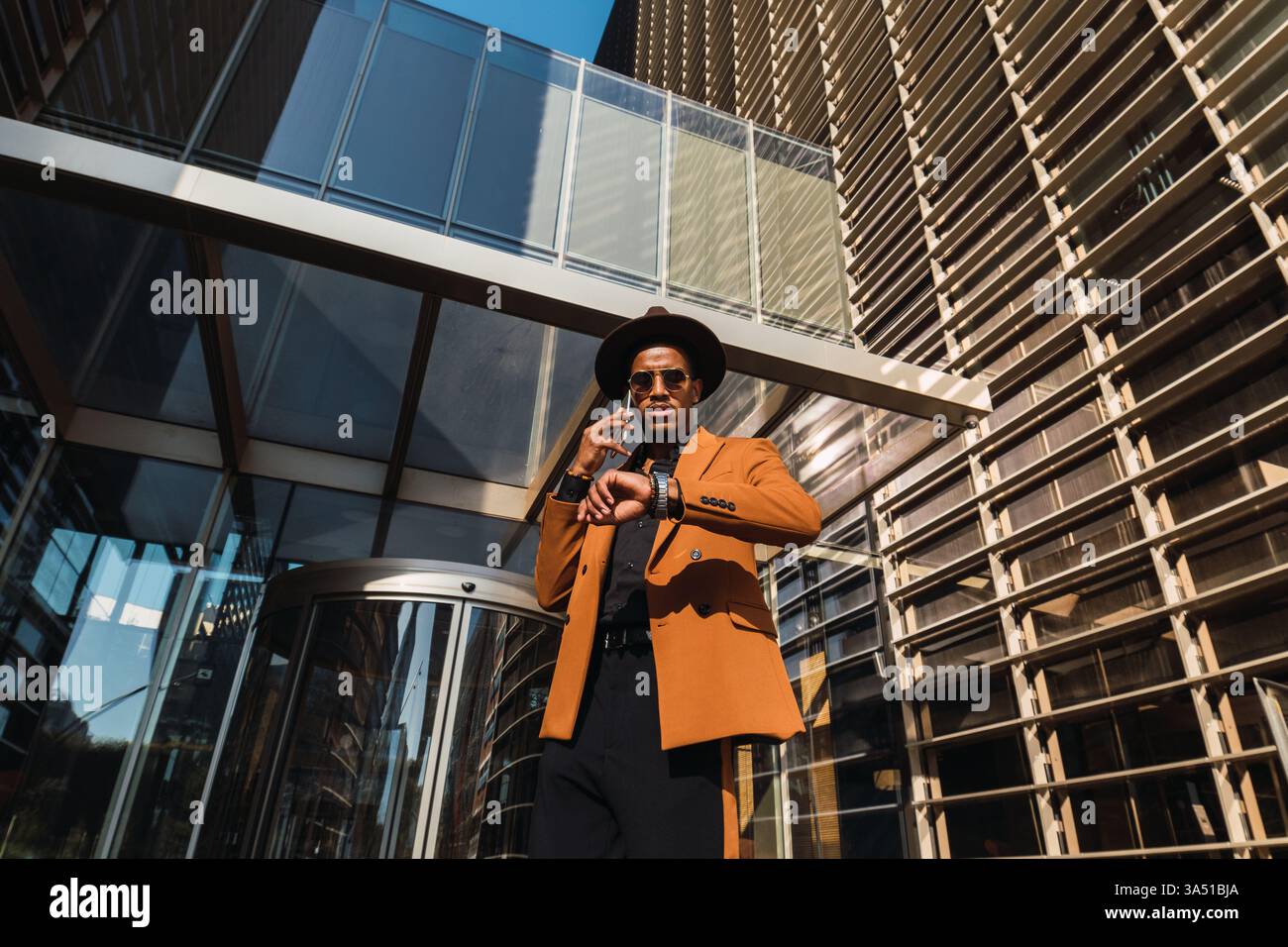 Hispanic businessman wearing sunglasses and fedora hat having phone ...