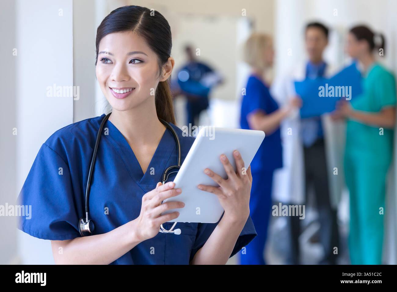 Asian Chinese female clinical hospital nurse in scrubs using wireless ...