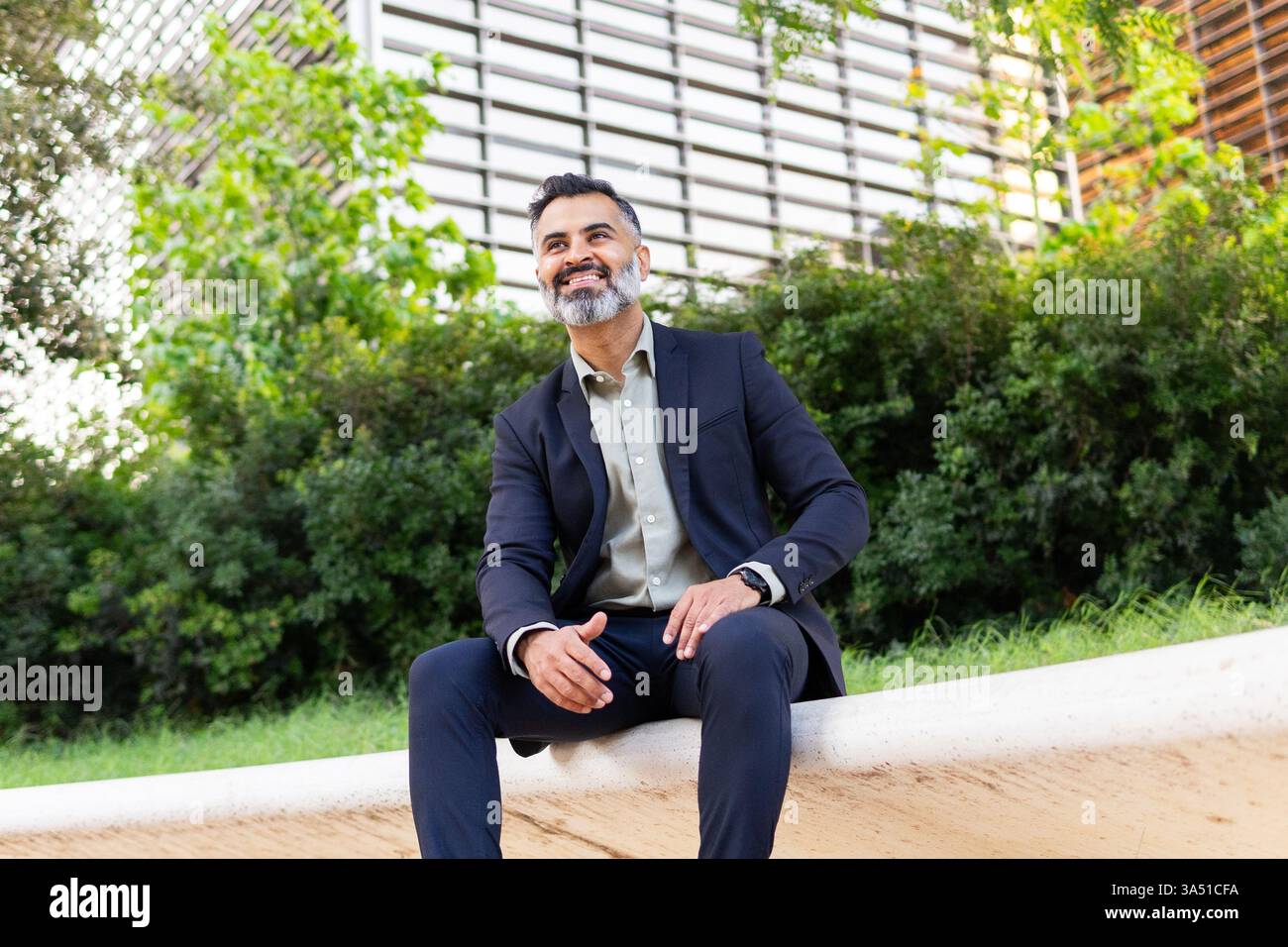 From below man in formal business attire is seated outdoors with a ...
