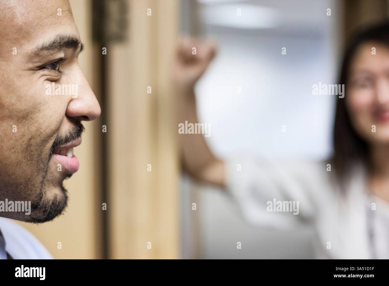 Smiling Black businessman standing and talking to officemates in the ...