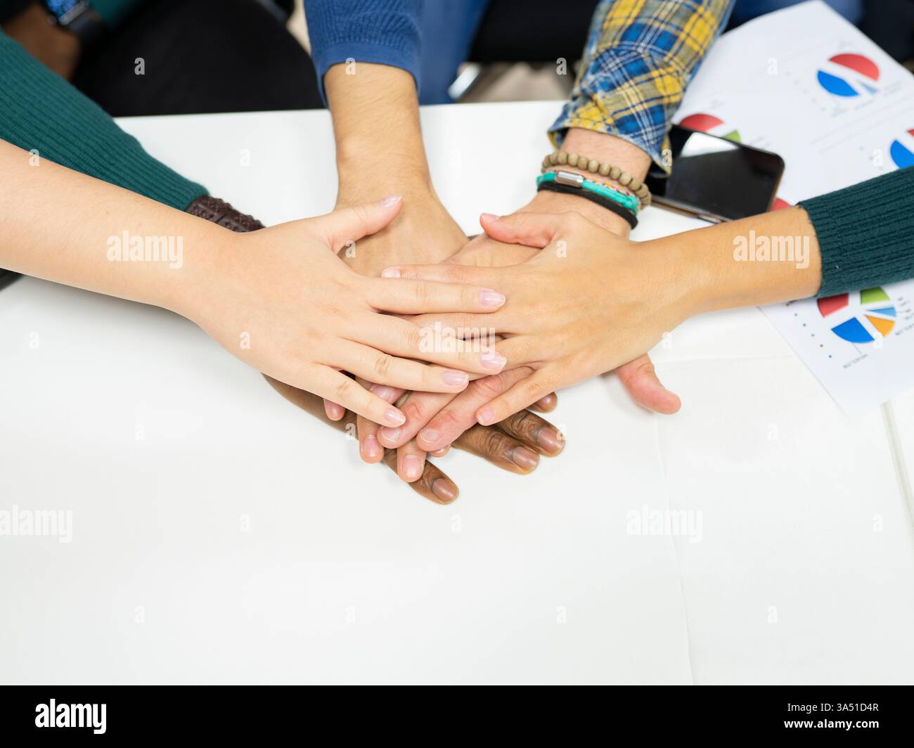 From above of crop anonymous multiracial colleagues in casual clothes ...