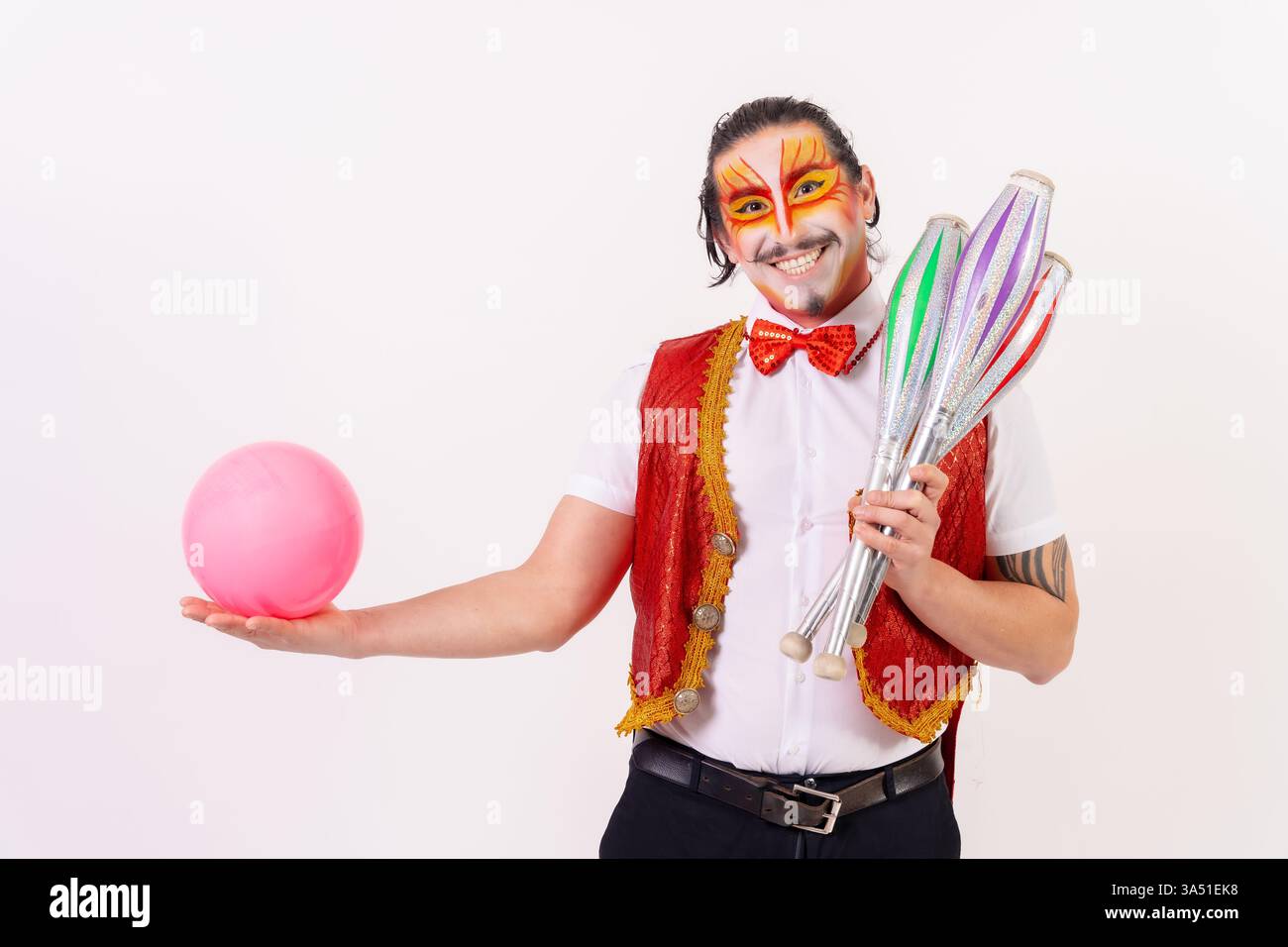 Portrait of a juggler smiling with juggling mallets and a ball isolated on white background ...