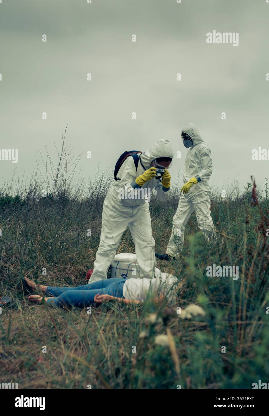 Black and Caucasian health workers taking photo of dead body in lawn ...