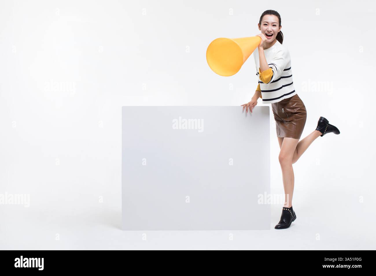 Chinese woman shouting on megaphone holding on whiteboardwhile standing ...