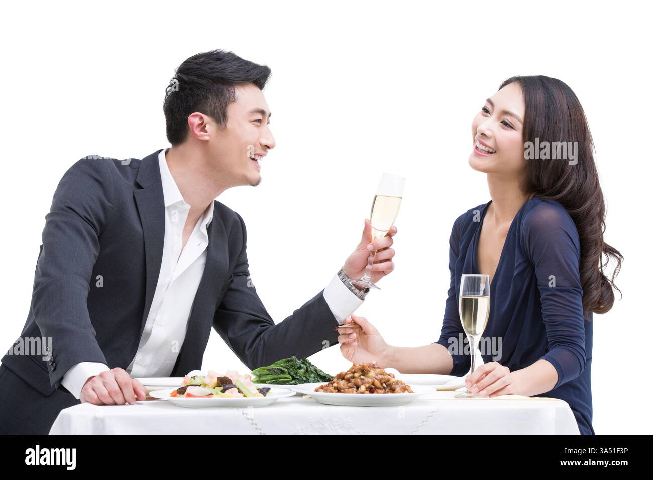Joyful young Chinese couple enjoying a dinner together in a stylish ...